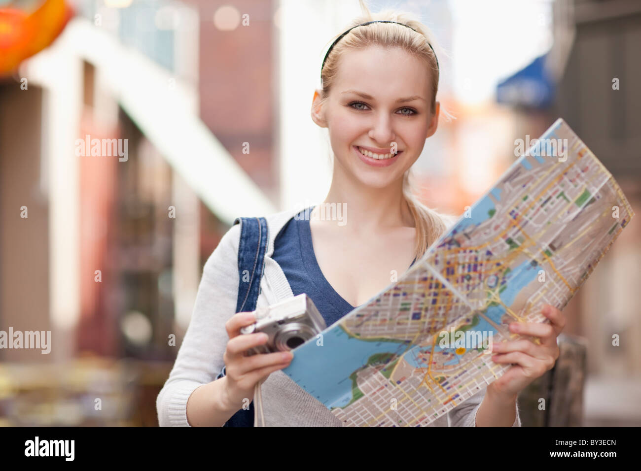 USA, Seattle, Smiling young woman holding map Stock Photo - Alamy