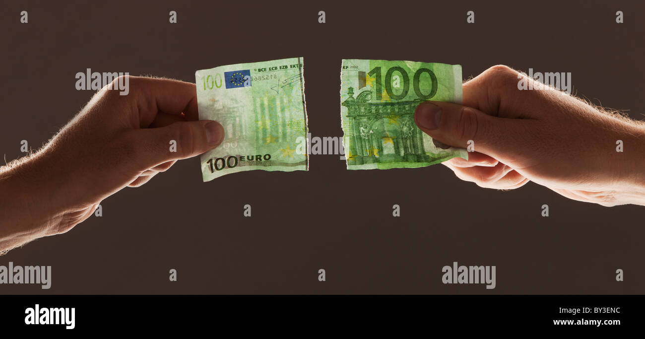 Hands holding torn one hundred euro note Stock Photo - Alamy
