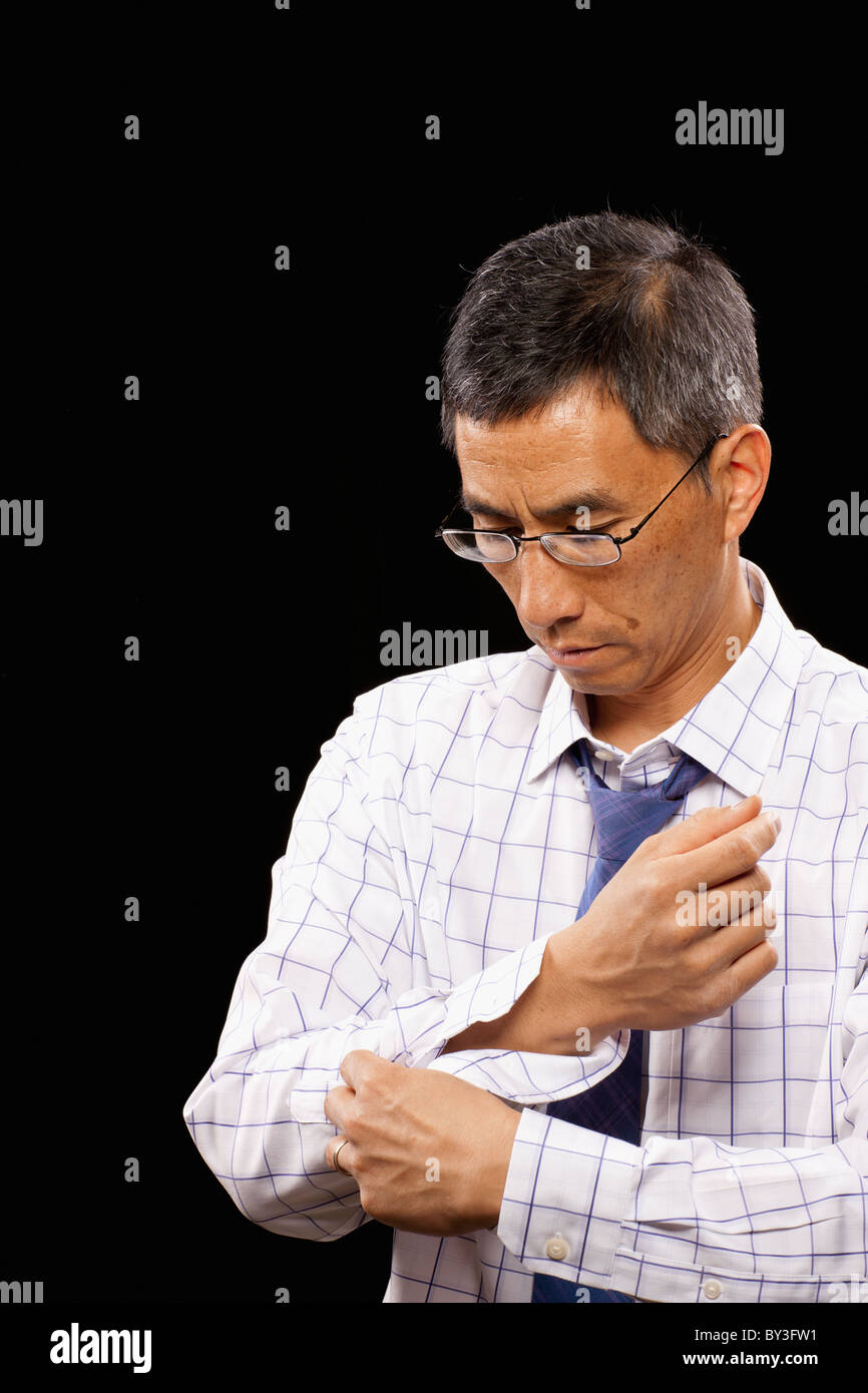 Studio shot of man buttoning cuff Stock Photo - Alamy