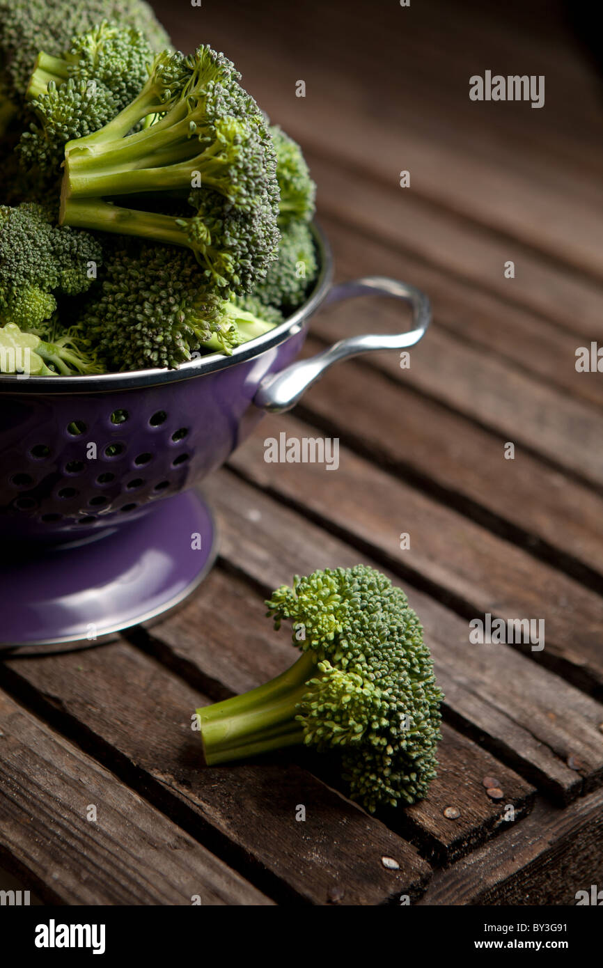 Broccoli in purple colander on rustic wood surface Stock Photo - Alamy