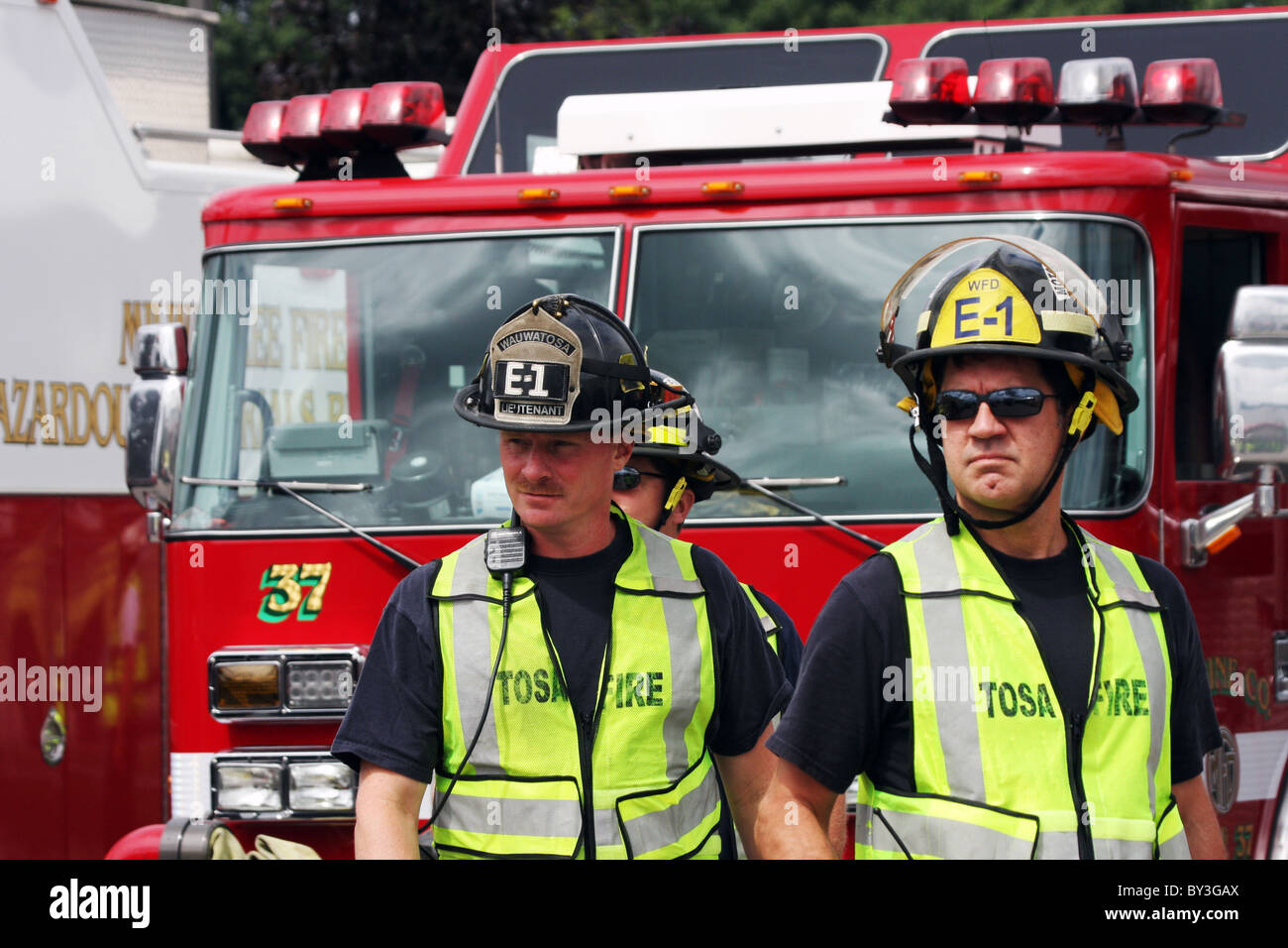 Firefighters standing in front of emergency vehicles fire truck Stock ...