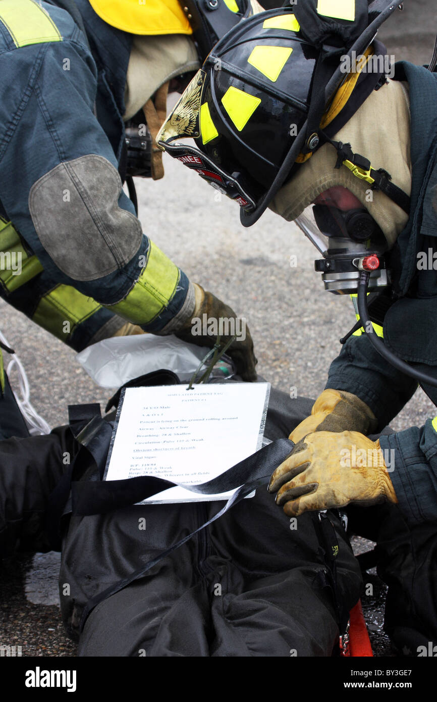Two firefighters working on a simulate patient dummy at an emergency ...
