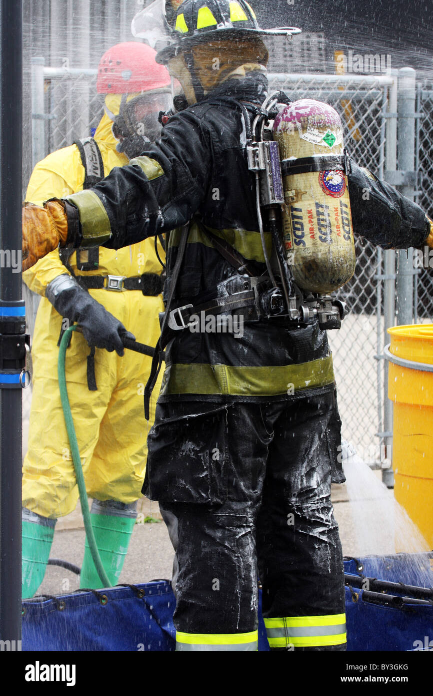 A firefighter getting scrubbed down after a chemical haz mat spill ...