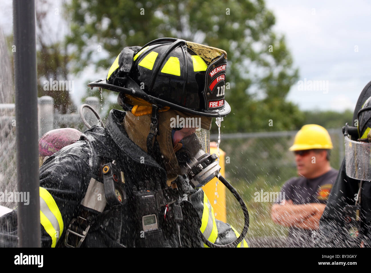 A firefighter getting sprayed down after a chemical haz mat spill ...
