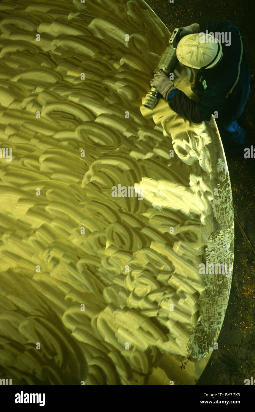 Overhead view of worker polishing propeller at shipyard in Busan, South ...