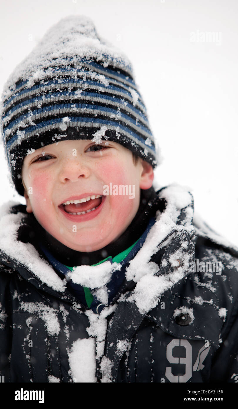 A young boy with rosy cheeks playing in the snow, Worcestershire, UK ...