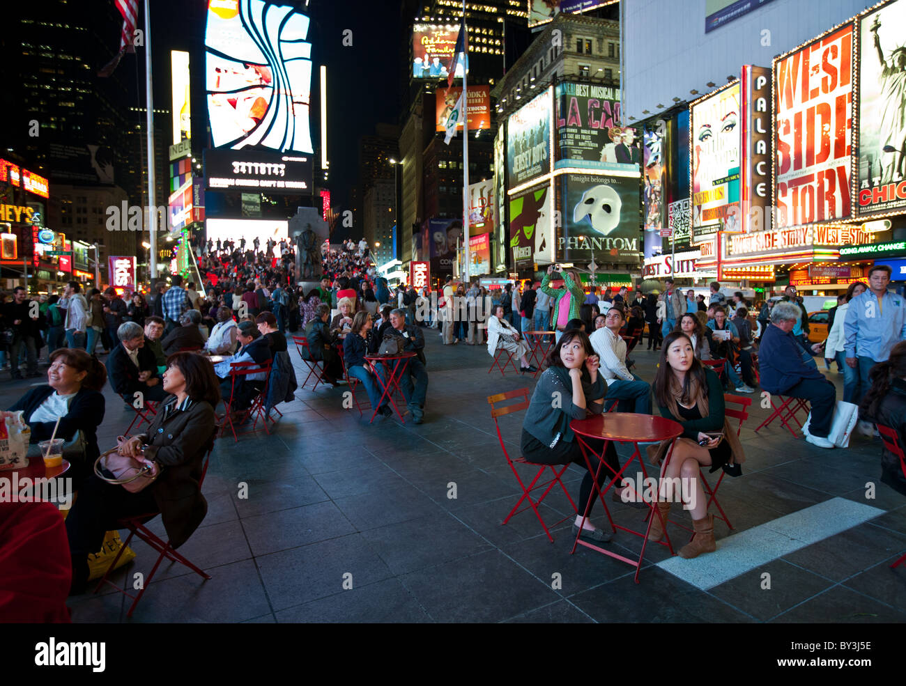 U.S.A., New York, Manhattan, people and neon sign in Times Square area ...
