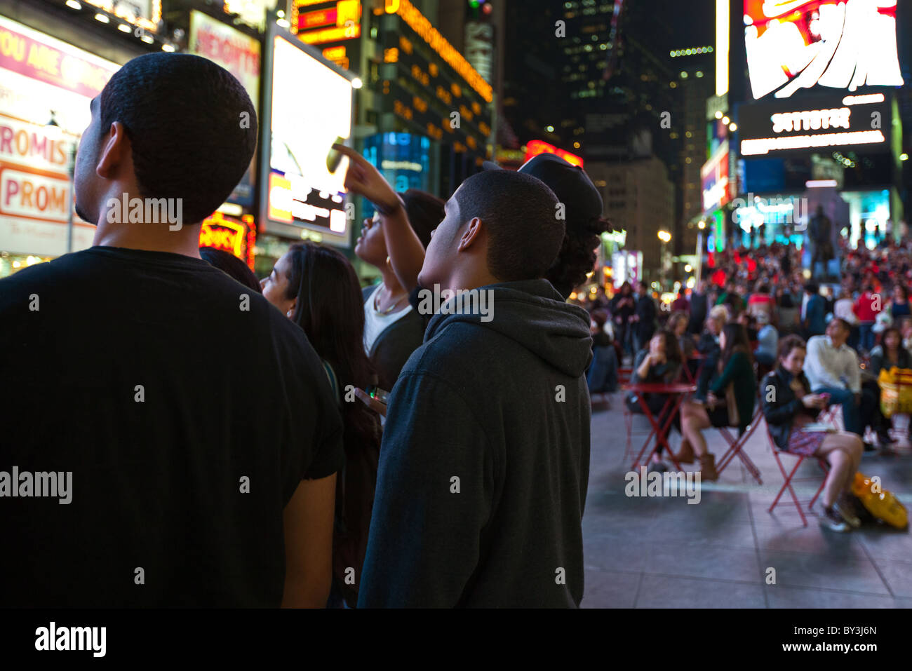 U.S.A., New York, Manhattan, people and neon sign in Times Square area ...
