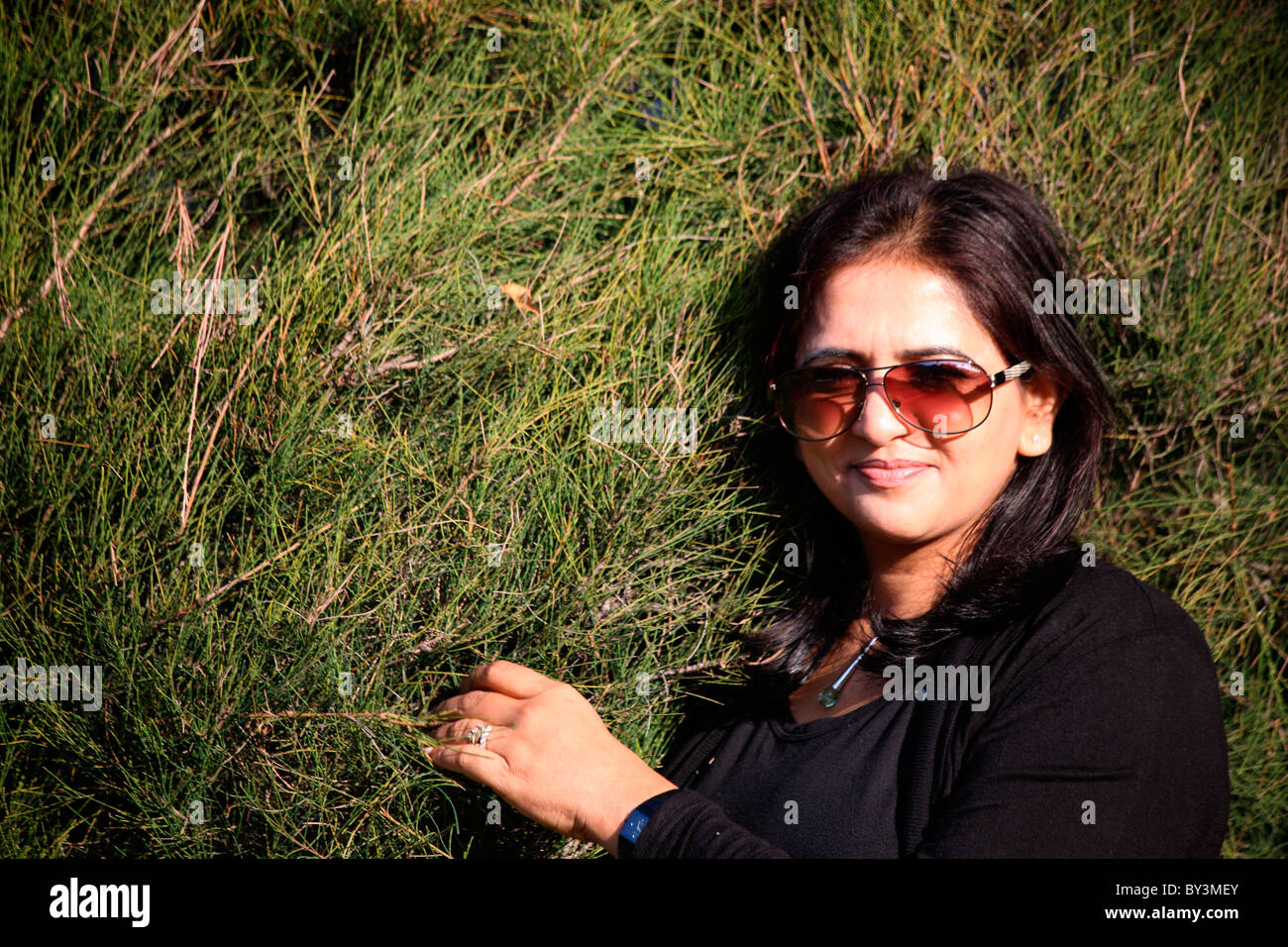 A portrait of Indian woman against tree leaves background Stock Photo ...