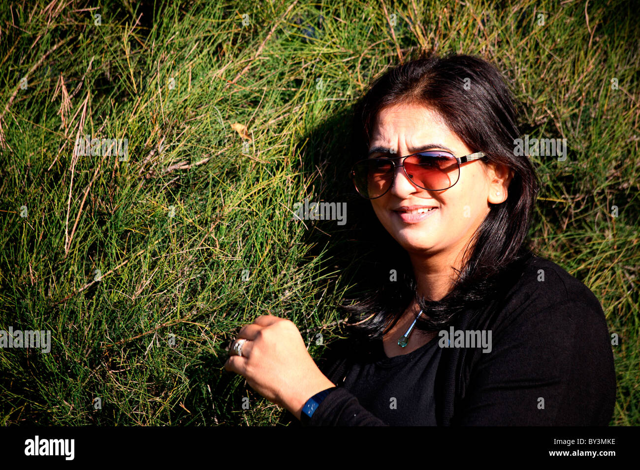 A portrait of Indian woman against tree leaves background Stock Photo ...