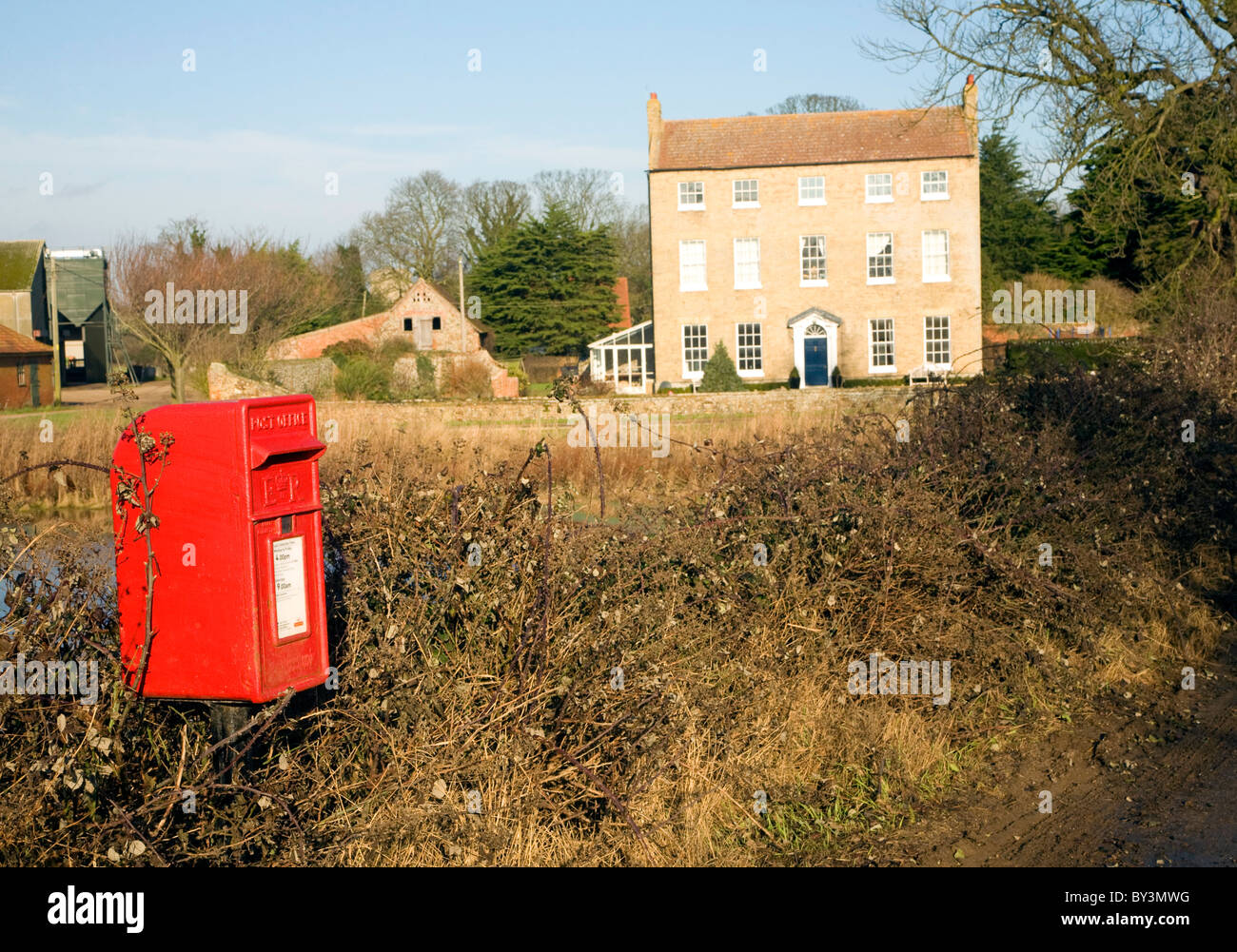 Red rural post box farmhouse in background Stock Photo - Alamy