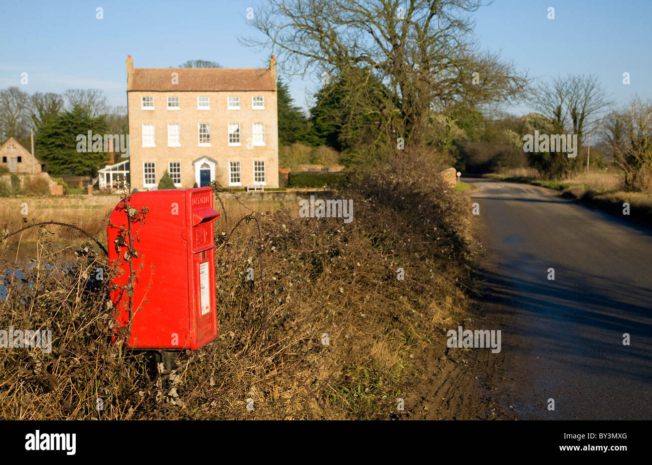 Red rural post box farmhouse in background Stock Photo - Alamy