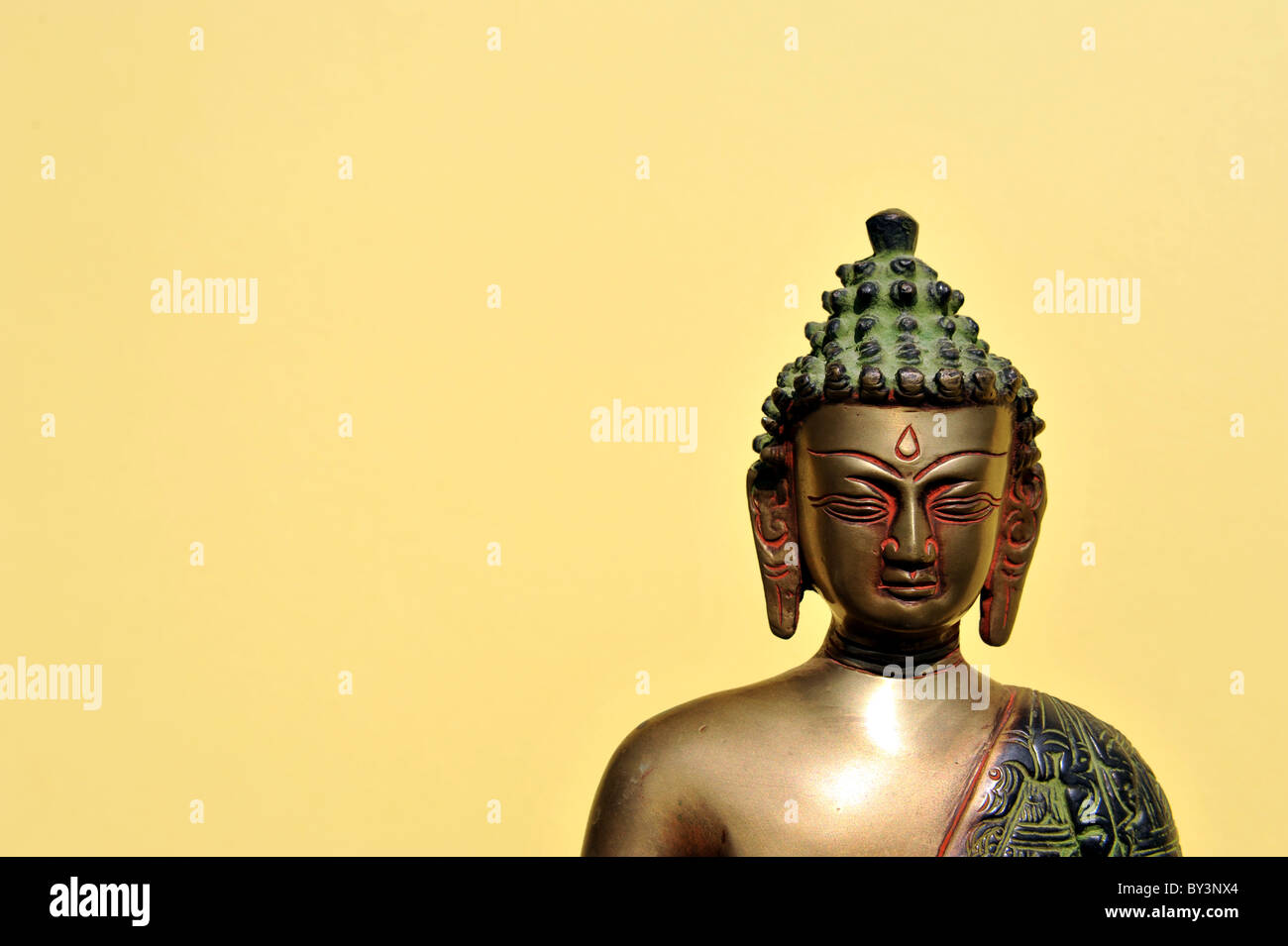 Buddha statue with a yellow background Stock Photo - Alamy