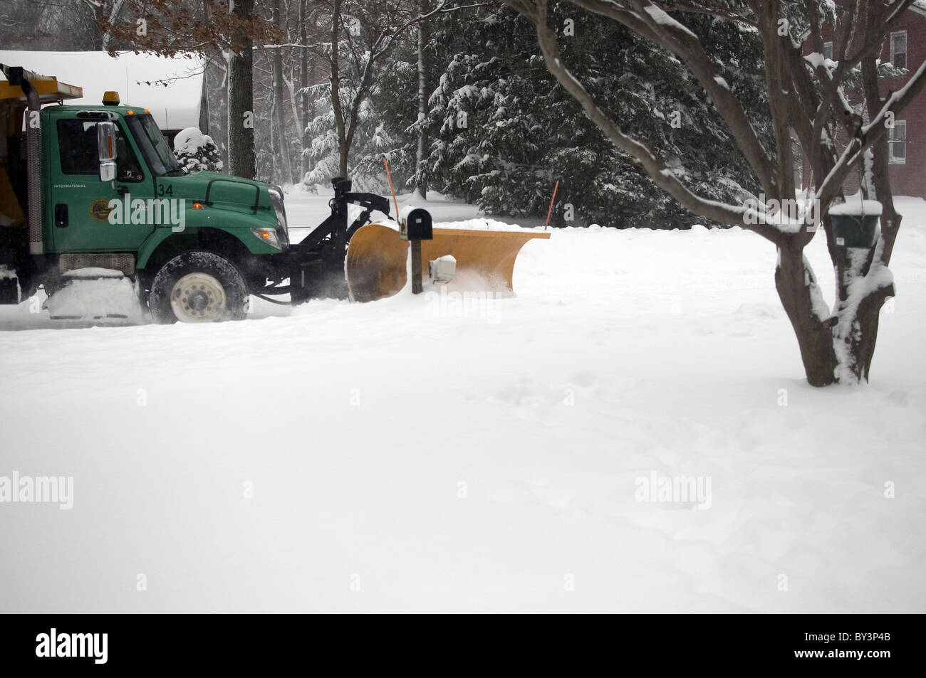 Truck plowing snow on neighborhood street in a snow storm Stock Photo ...