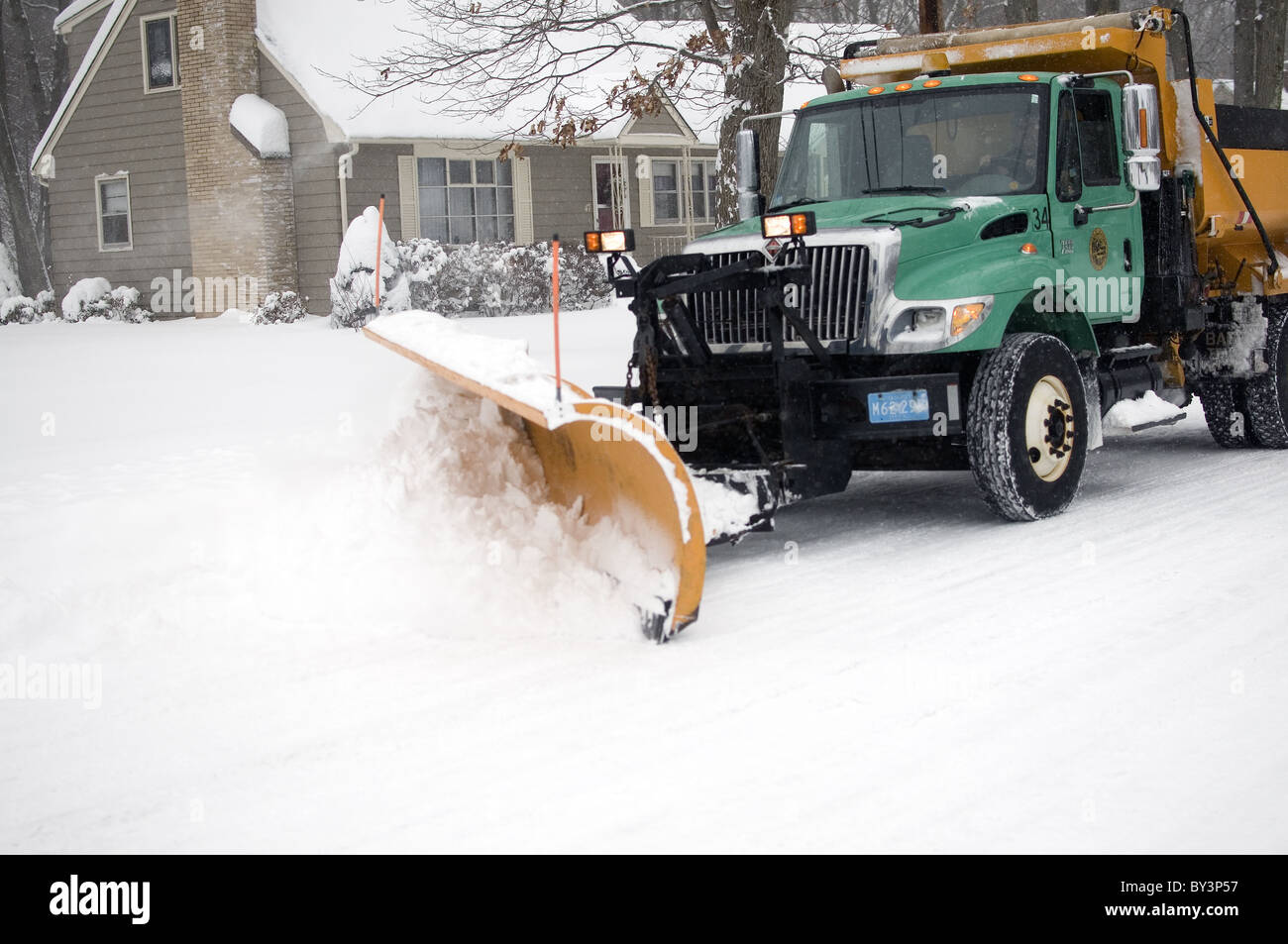 Truck plowing snow on neighborhood street in a snow storm Stock Photo ...