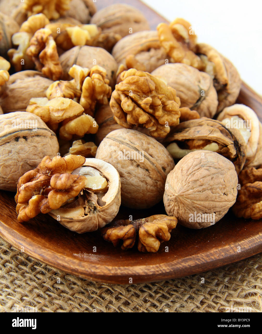 Whole and chopped walnuts on a brown background Stock Photo - Alamy