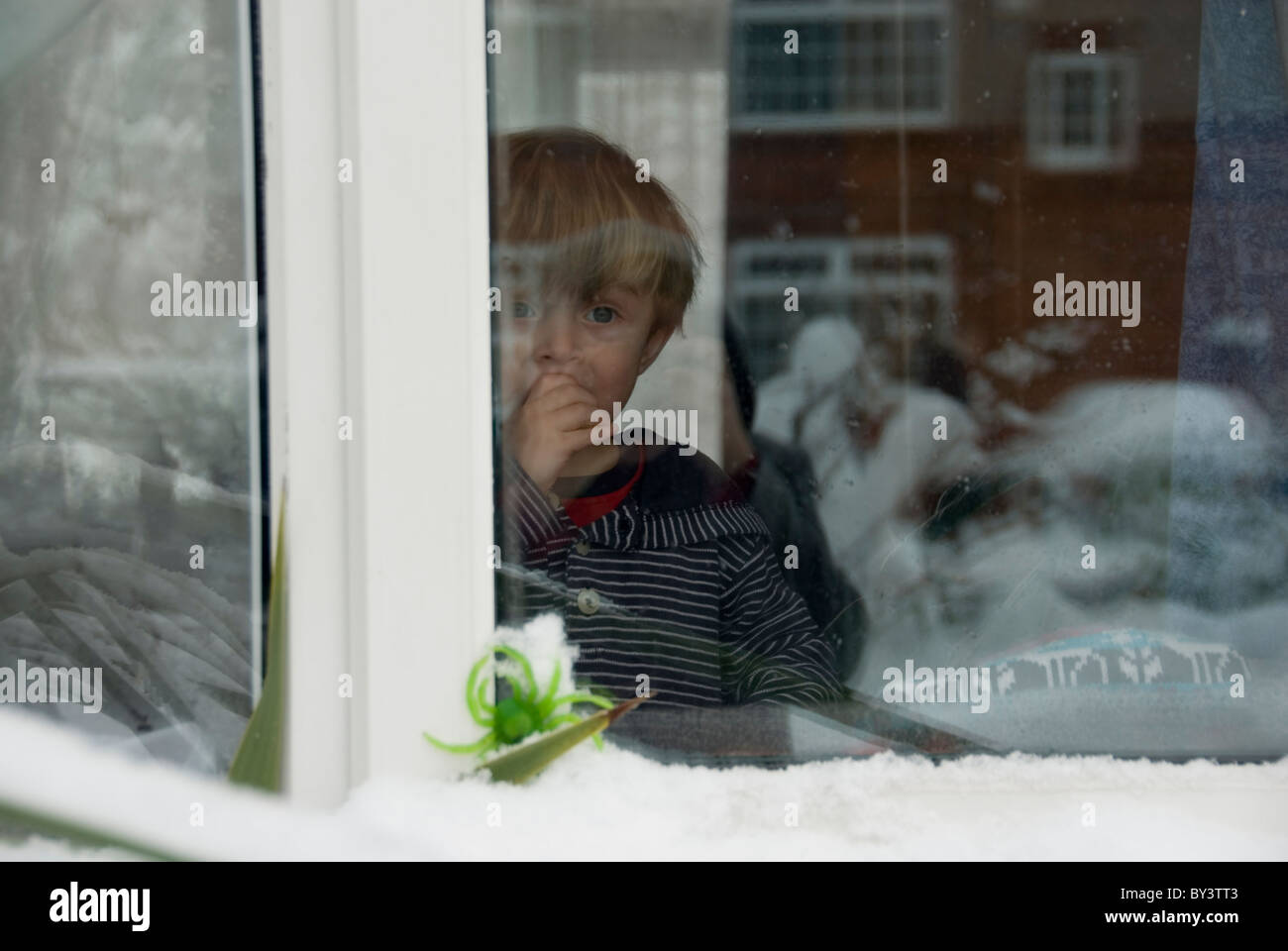 Little Boy in Window Reflecting Scene of Winter Snow Stock Photo - Alamy