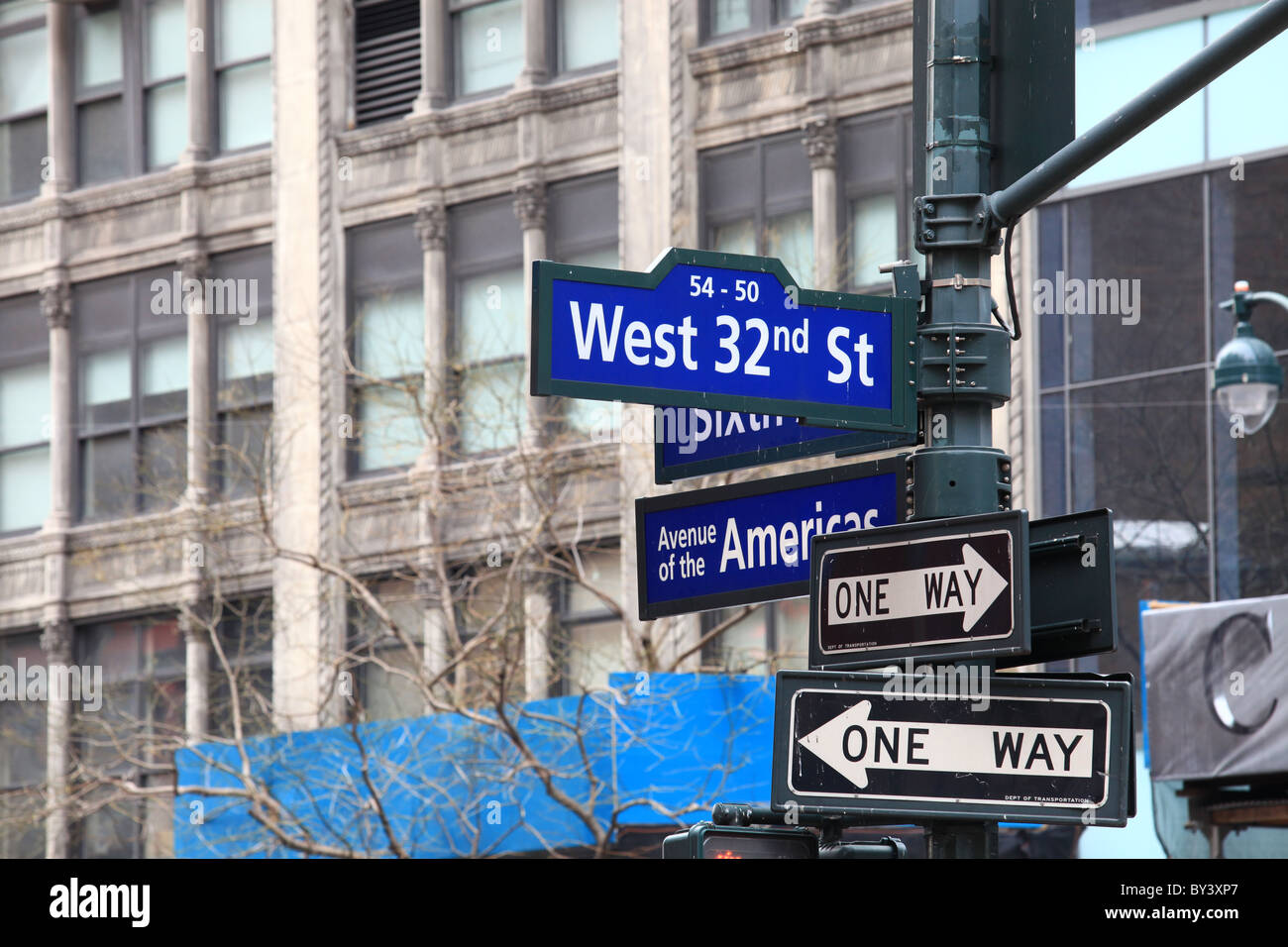Street signs at the intersection of 32nd st and Avenue of the Americas ...