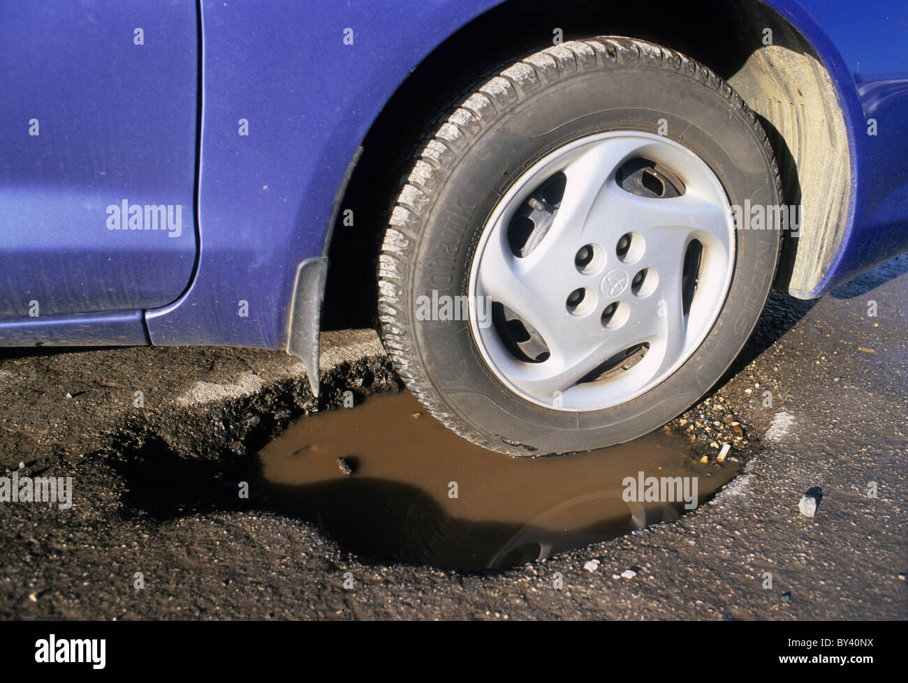 vehicle wheel in pothole on road uk Stock Photo - Alamy