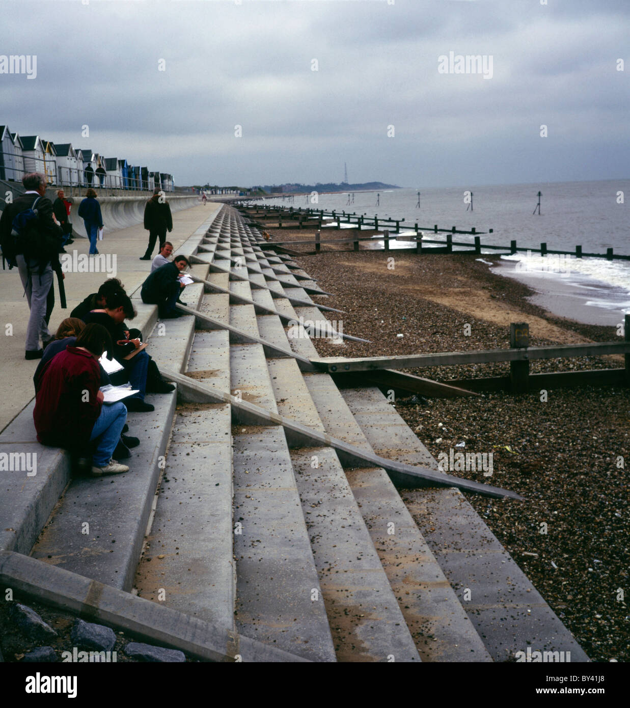Geography students sitting concrete steps beach Felixstowe Suffolk ...