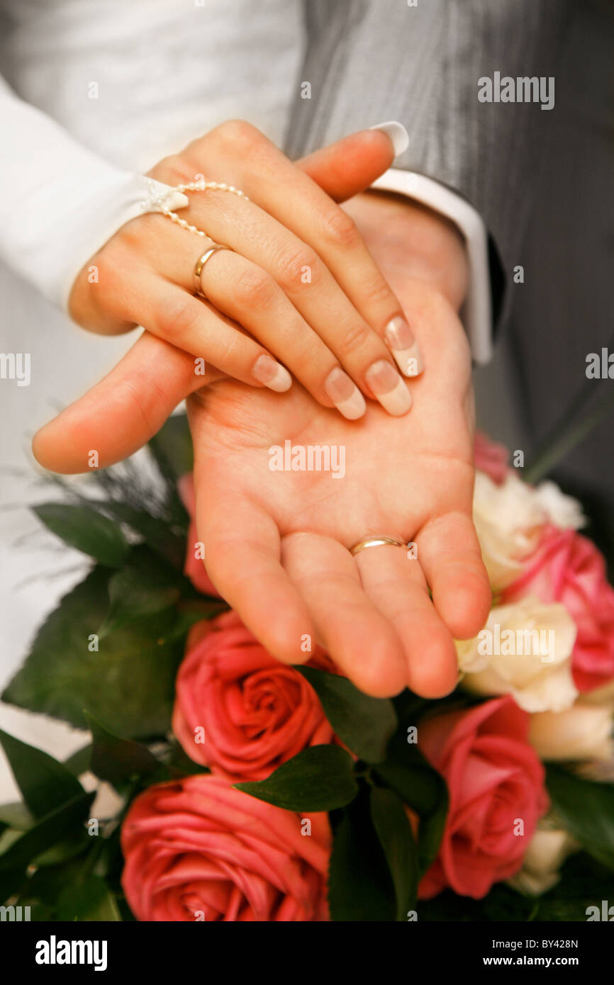 Photo of hands of newly-married over bunch of flowers Stock Photo - Alamy