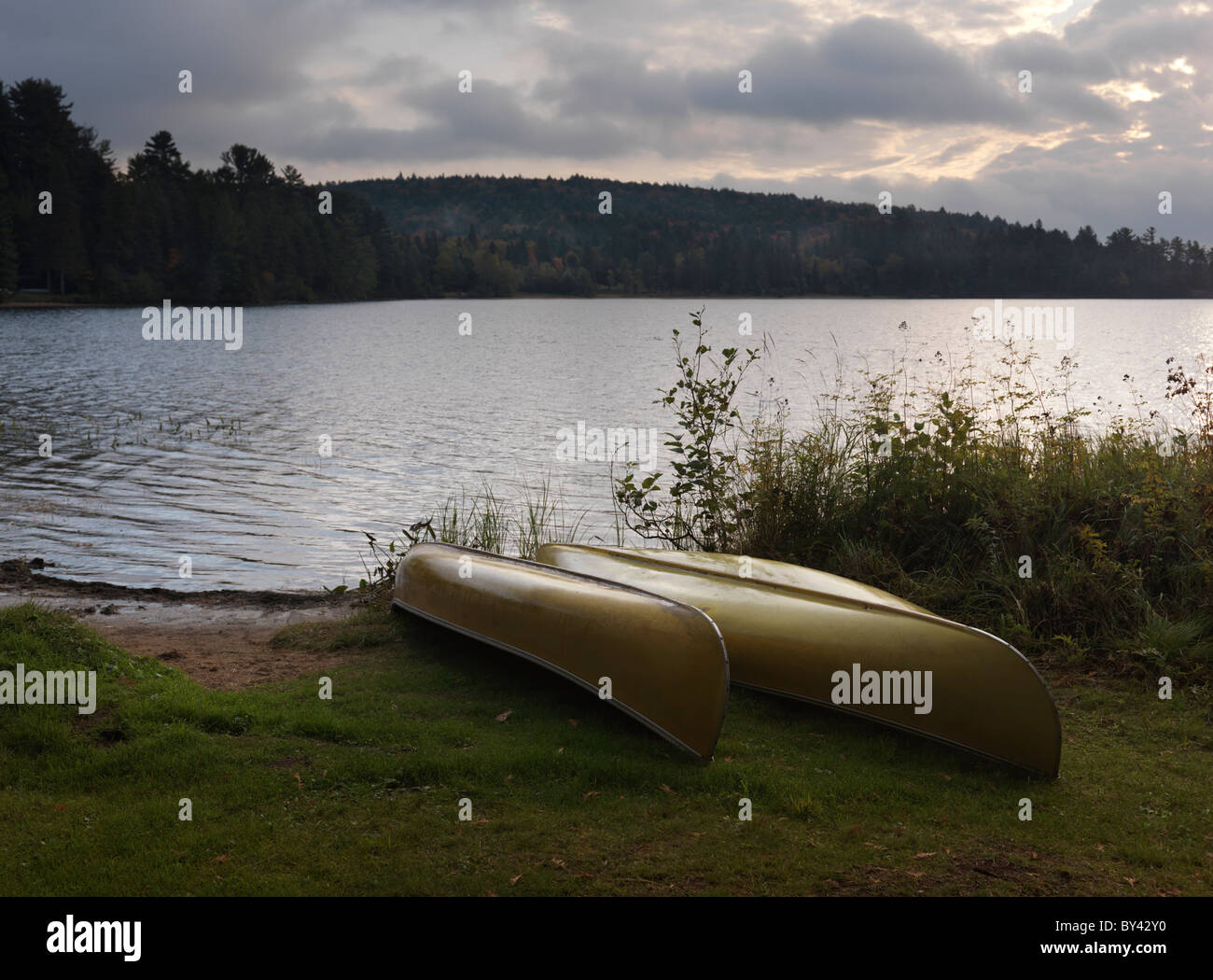 Two canoe on a shore of The Lake of Two Rivers at dawn tranquil fall ...
