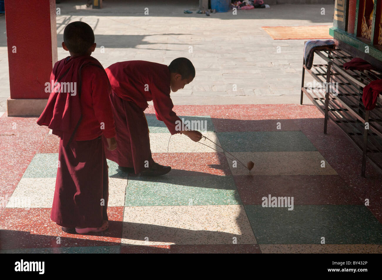 young Tibetan-Sherpa monks spinning a top at a monastery at Bodhnath in ...