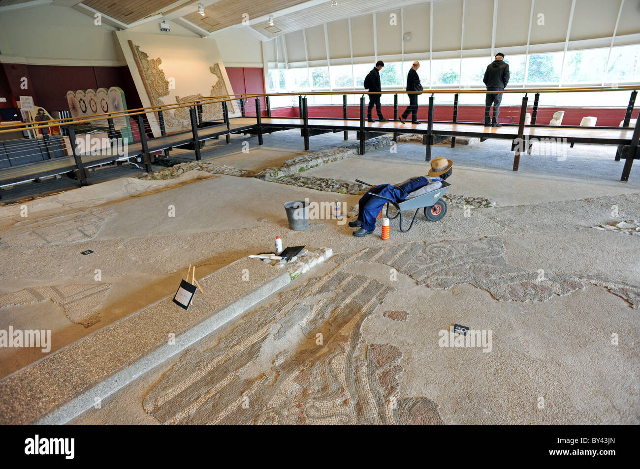 A dummy lies in a wheelbarrow amongst the mosaics at Fishbourne Roman ...