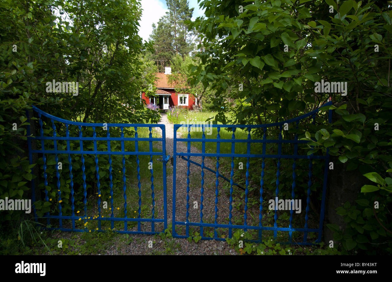 Small cottage with blue gate Stock Photo - Alamy
