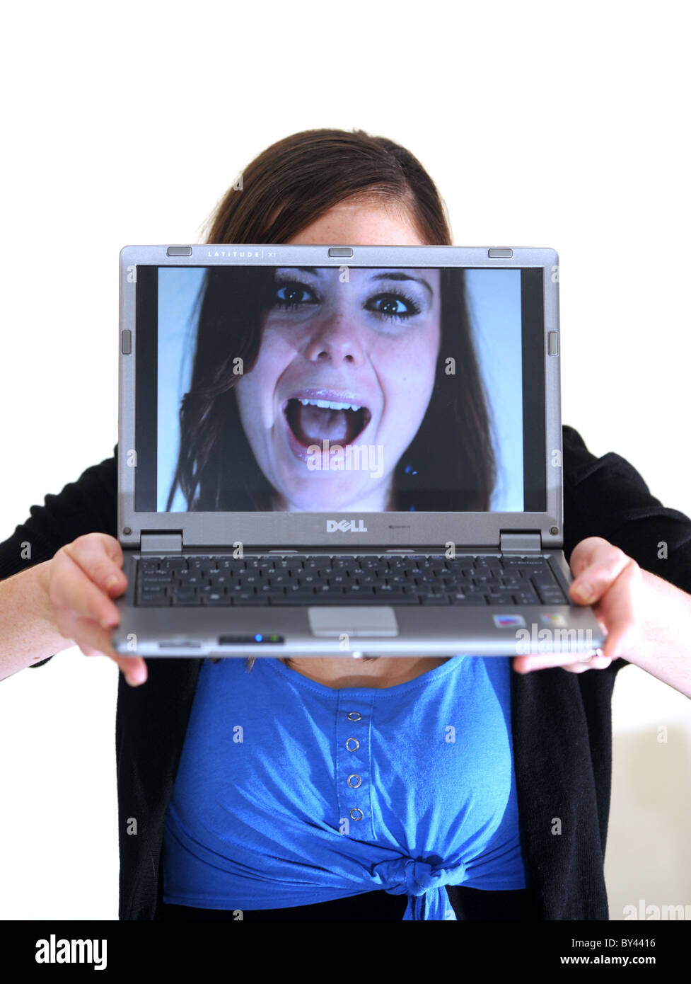 Young woman laughing mouth open using laptop computer with face on ...
