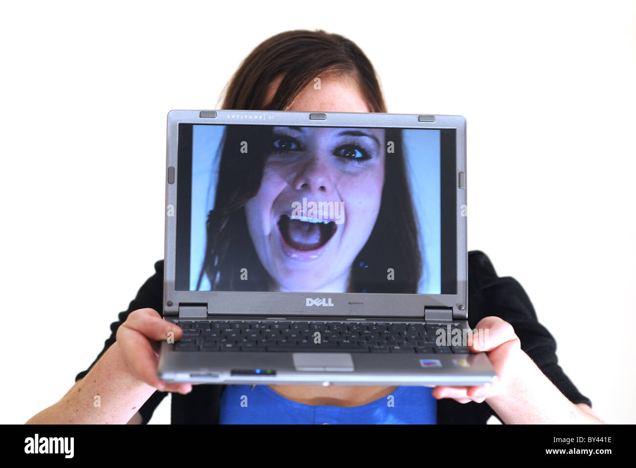 Young woman laughing mouth open using laptop computer with face on ...