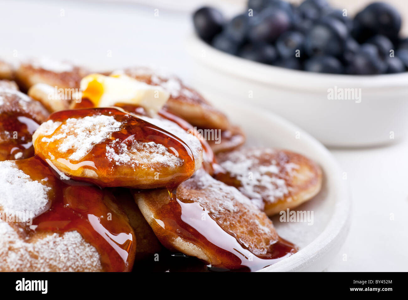 Dutch mini pancakes, or poffertjes, with butter, syrup and powdered ...