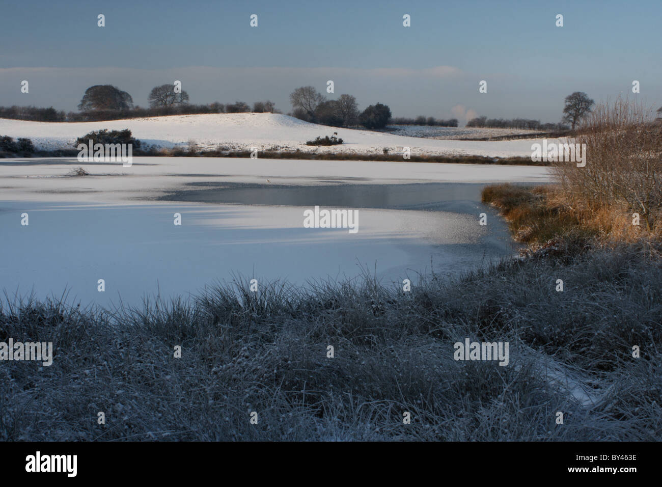 Snowfall on local fields and frozen pond in Borras Park Wrexham Stock ...