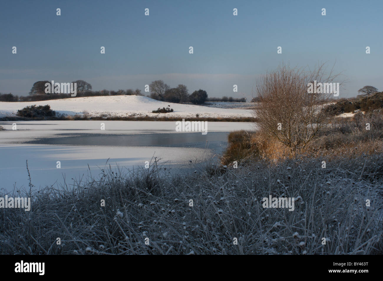 Snowfall on local fields and frozen pond in Borras Park Wrexham Stock ...