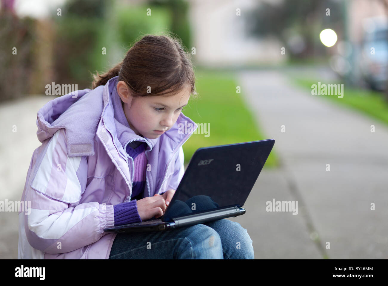 Eight year old girl with laptop outside Stock Photo - Alamy