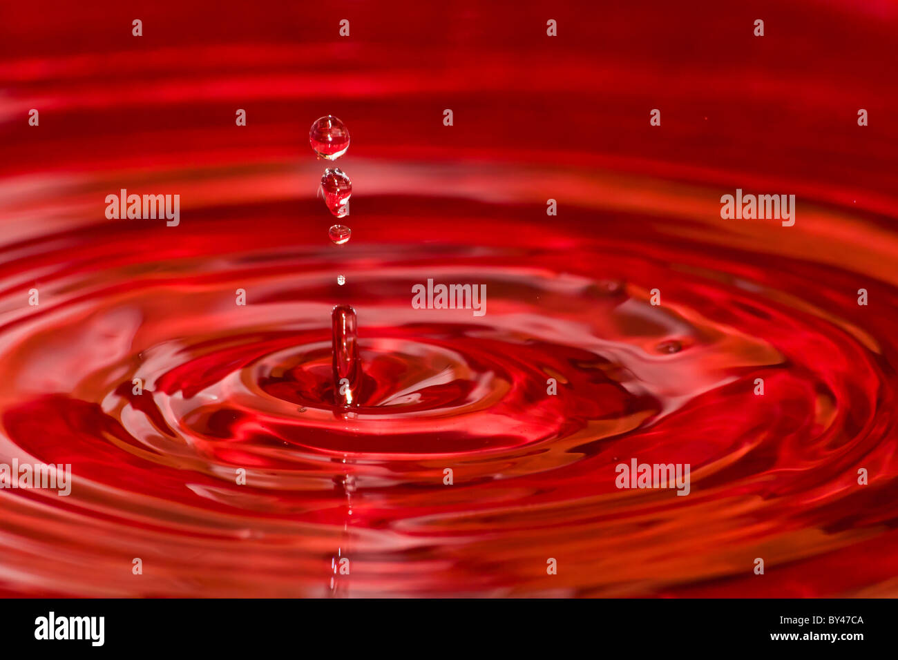 Water drops falling in water red/orange Stock Photo - Alamy
