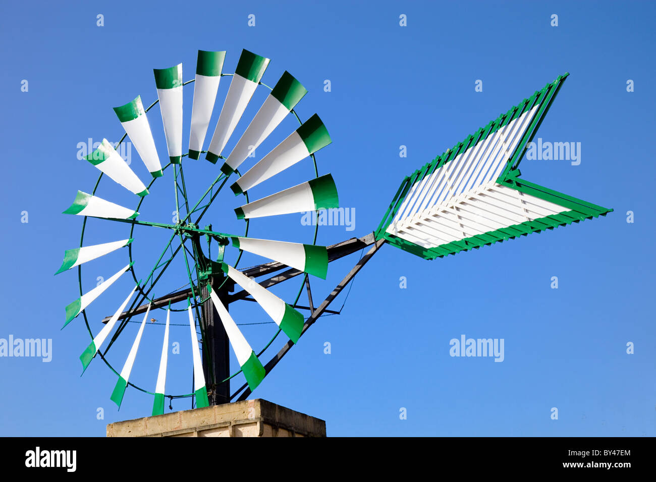 Isolated white and green windmill in Majorca with a blue sky as ...
