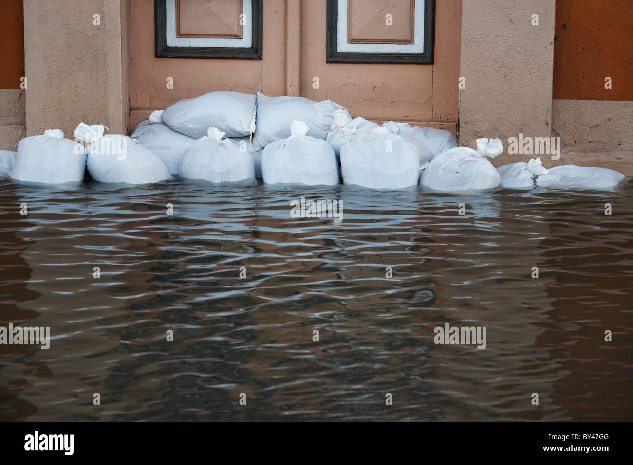 sandbags across the door of a house as protection against flooding of ...
