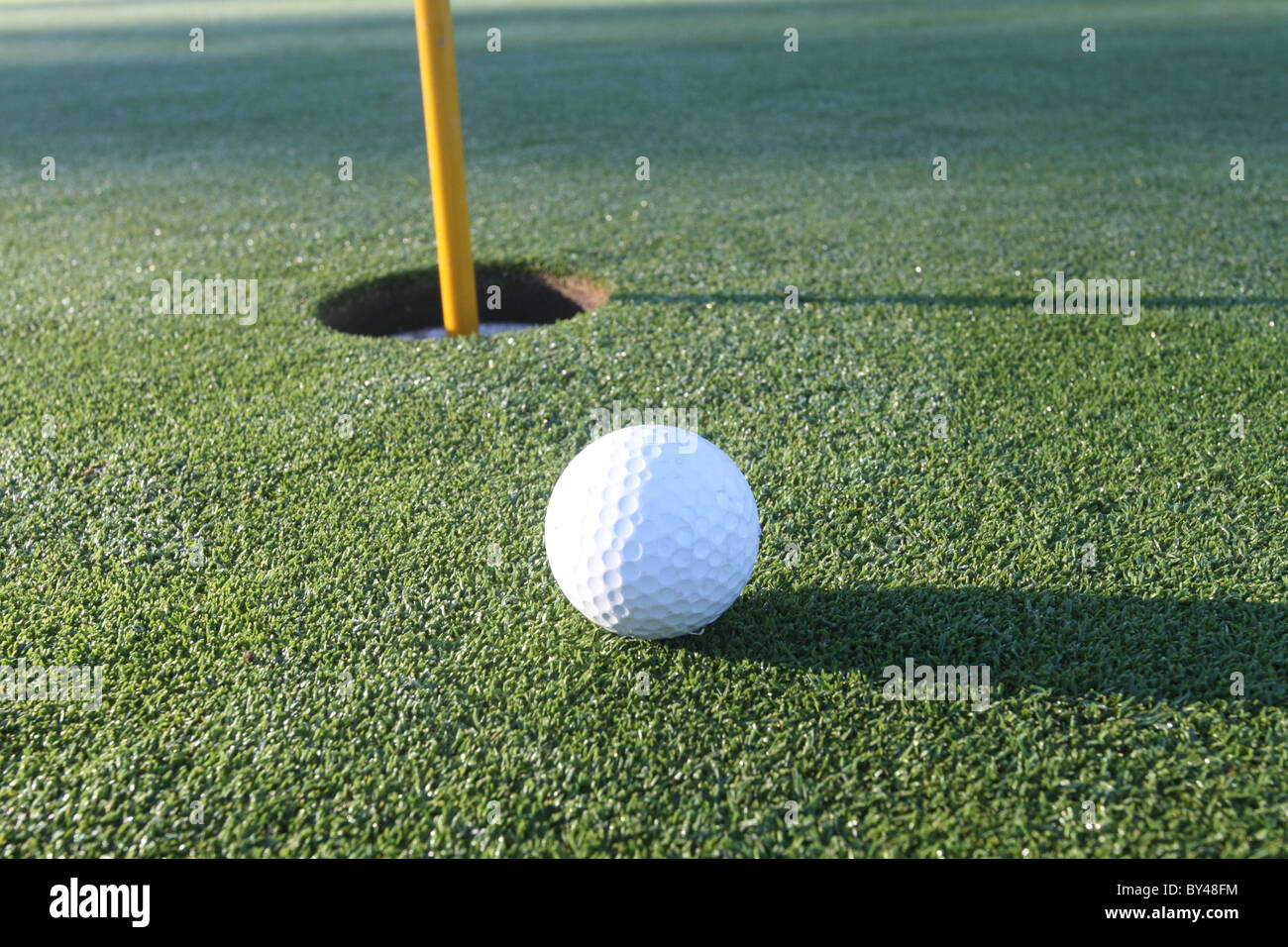 Golf Course Green with Golf Ball Near Hole Stock Photo - Alamy