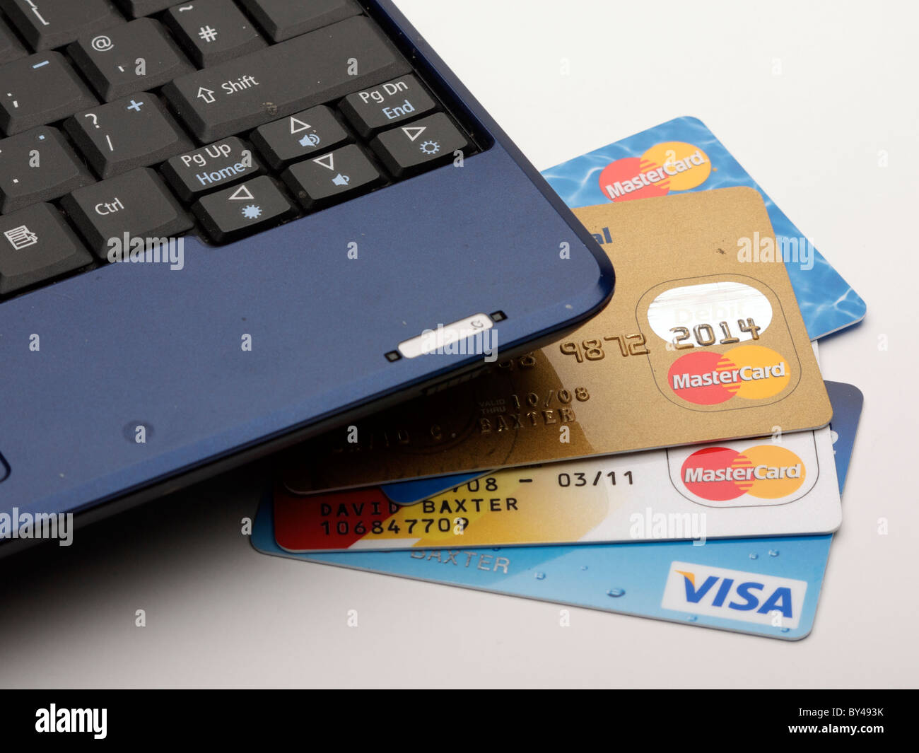 Credit cards under the corner of a laptop computer Stock Photo - Alamy