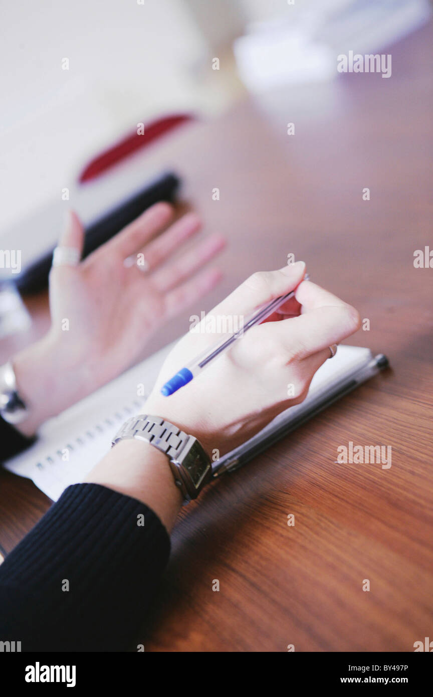 Detail of hands writing at an office meeting Stock Photo - Alamy