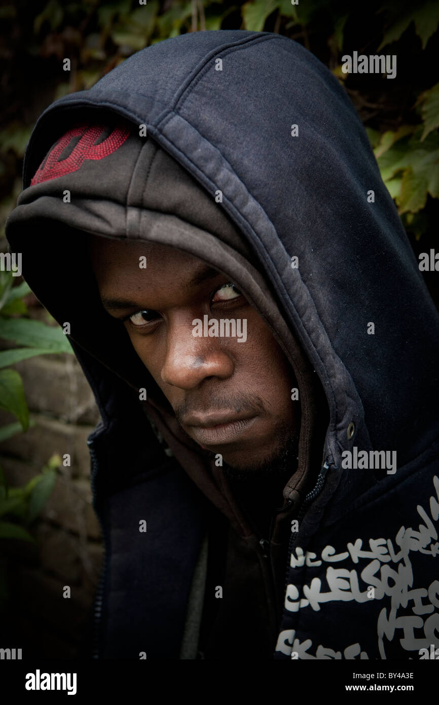 Young black model wearing a hoody and looking menacing Stock Photo - Alamy