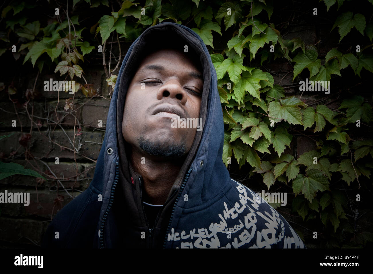 Young black model wearing a hoody and looking menacing Stock Photo - Alamy