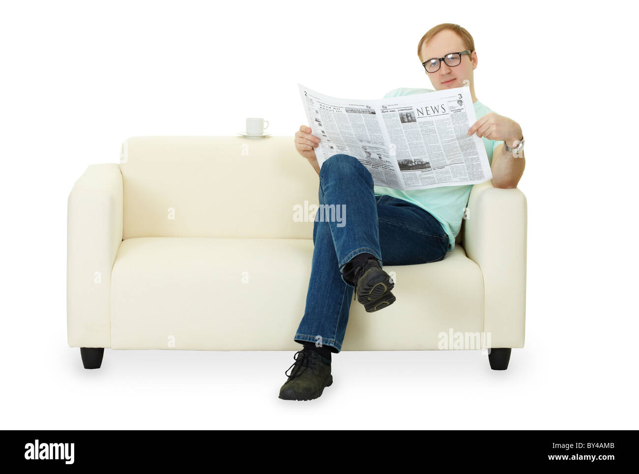 A man reading a newspaper at home sitting on the sofa Stock Photo - Alamy