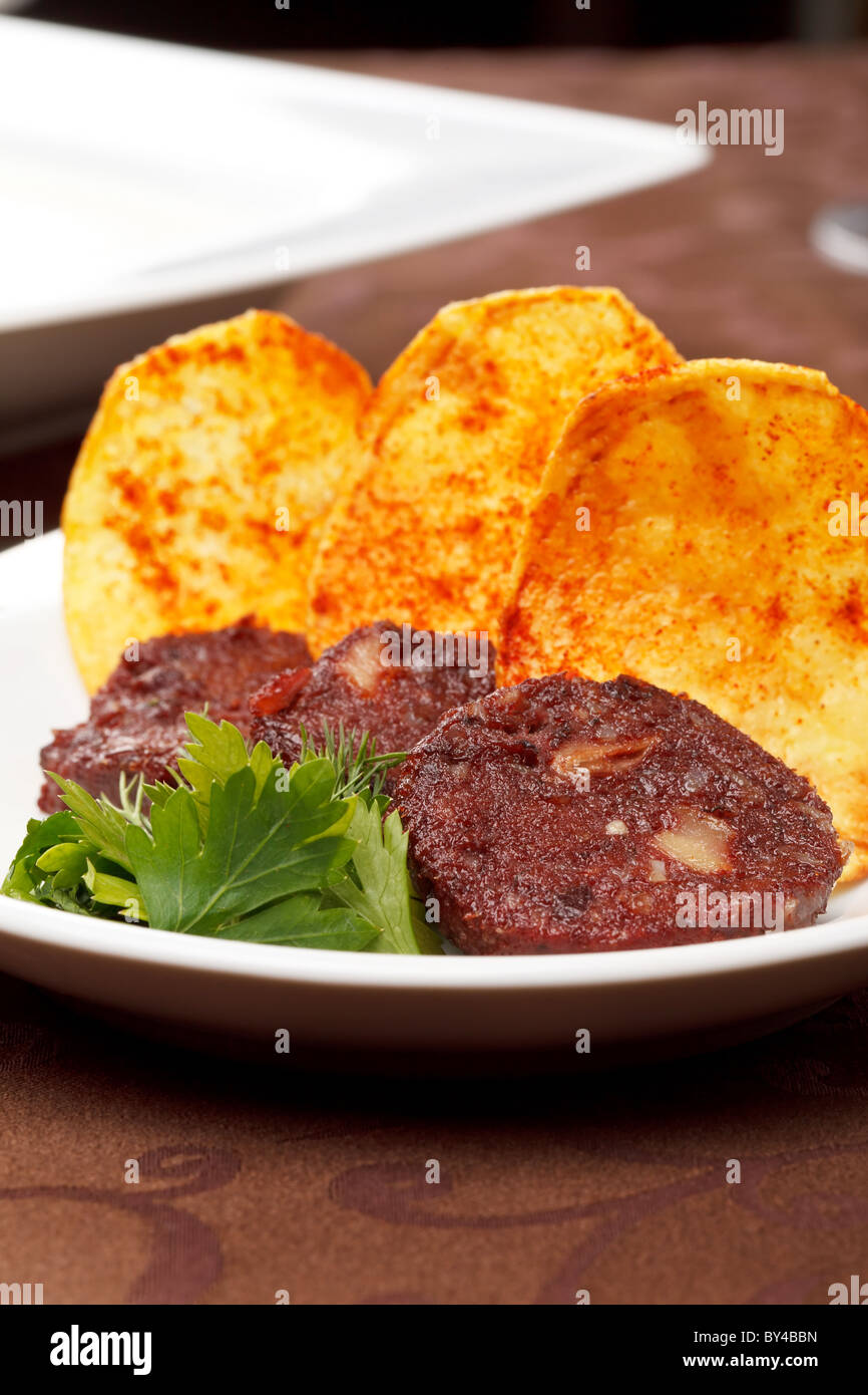 Black pudding sausage and potato chips Stock Photo - Alamy