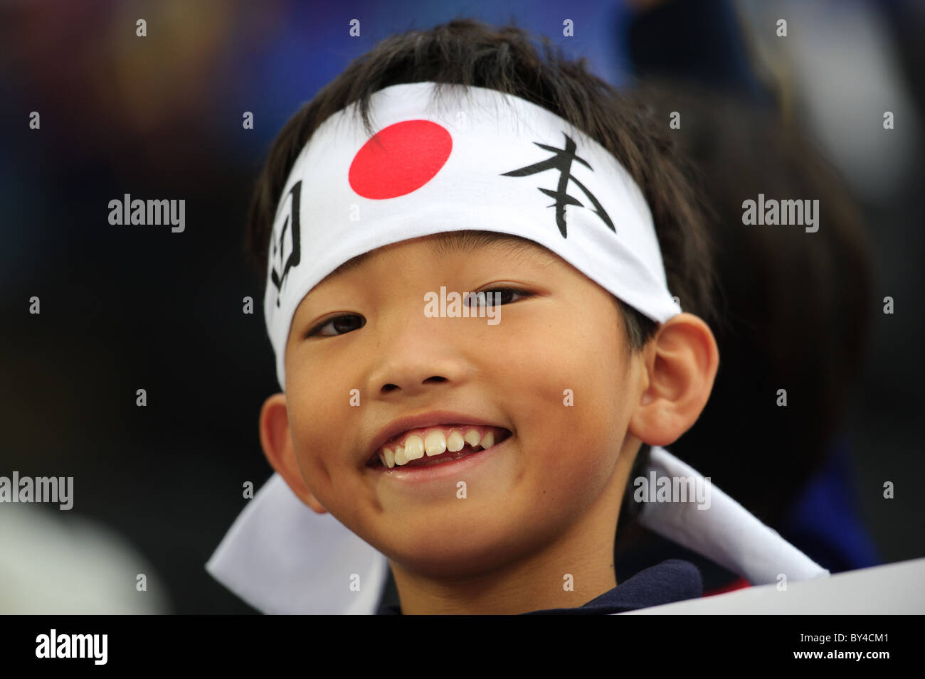 A young boy, fan of the Japan national football team wearing a bandanna ...