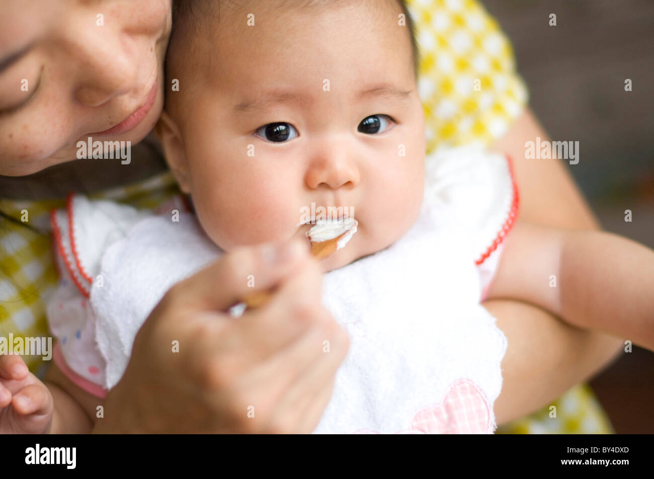 Mother feeding baby girl Stock Photo - Alamy