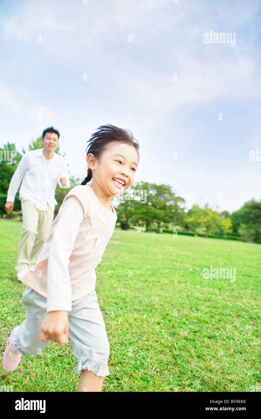 Father and daughter running on grass Stock Photo - Alamy
