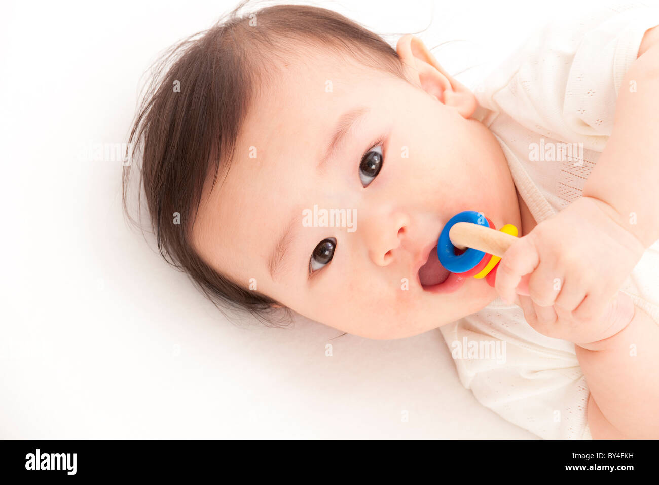 Baby Boy Biting Toy Stock Photo - Alamy