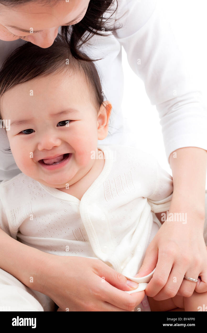 Mother Buttoning Baby Boy's Top Stock Photo - Alamy